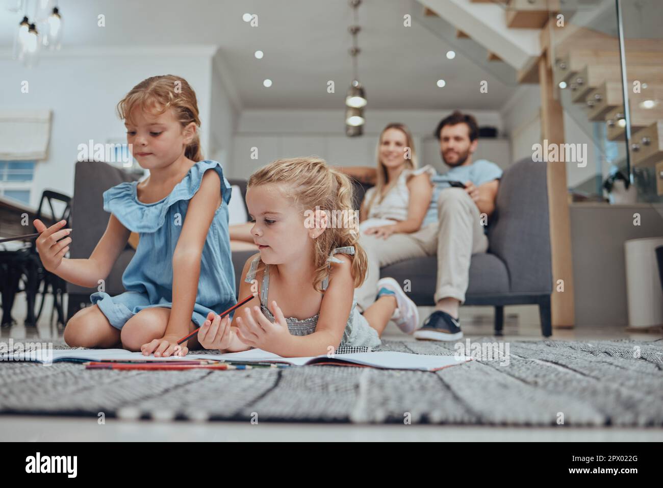 Relax, children drawing and parents on sofa in the living room bonding ...