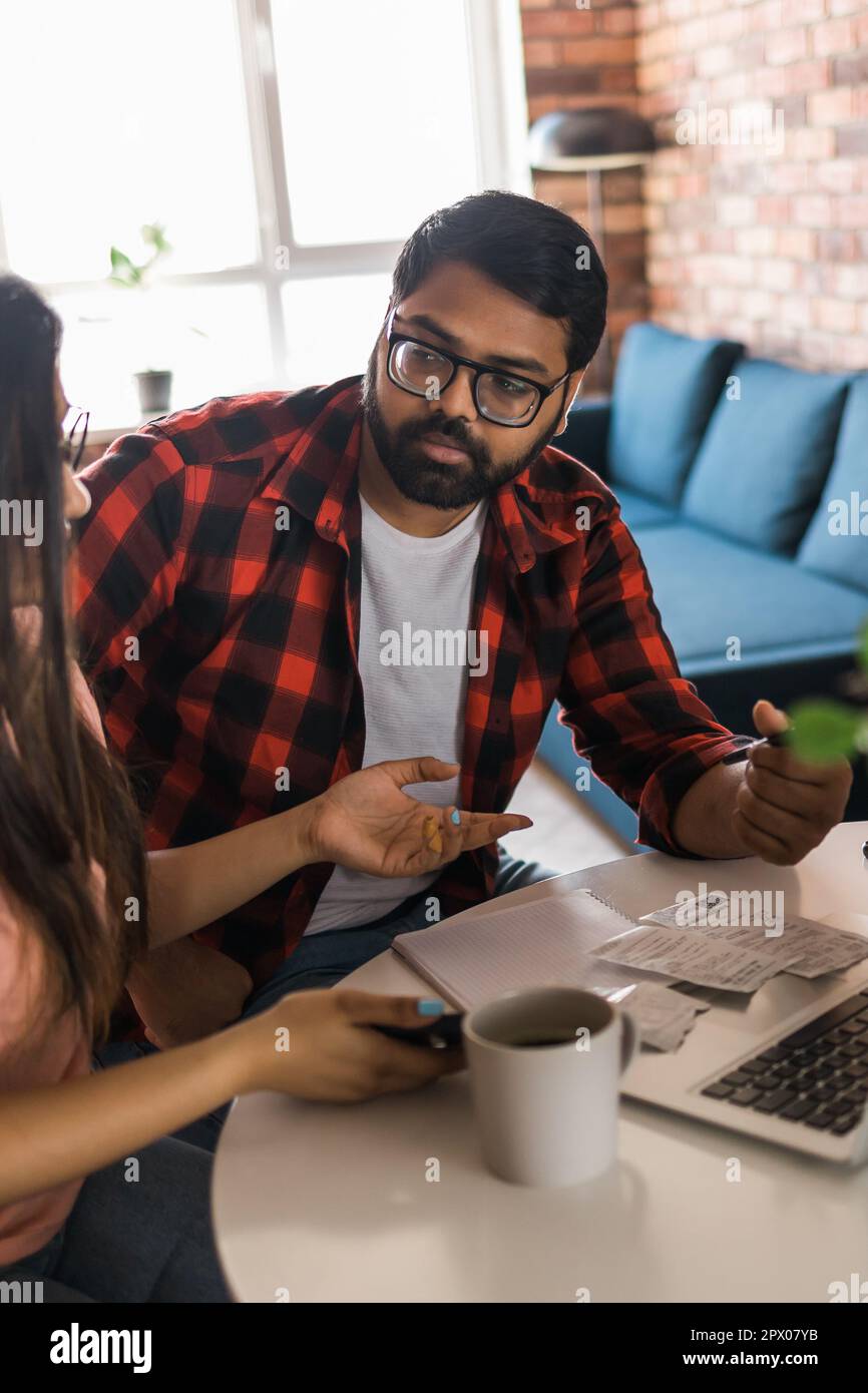 Young millennial indian husband and wife doing domestic paperwork ...