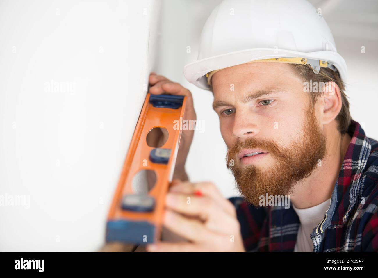 handyman measuring angle of wall with level Stock Photo - Alamy