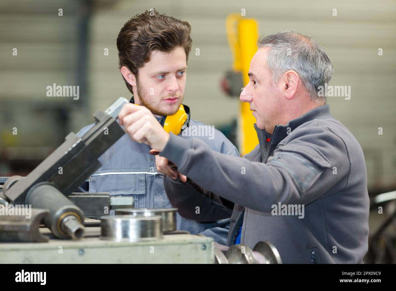 man explaining working of machine to trainee Stock Photo - Alamy