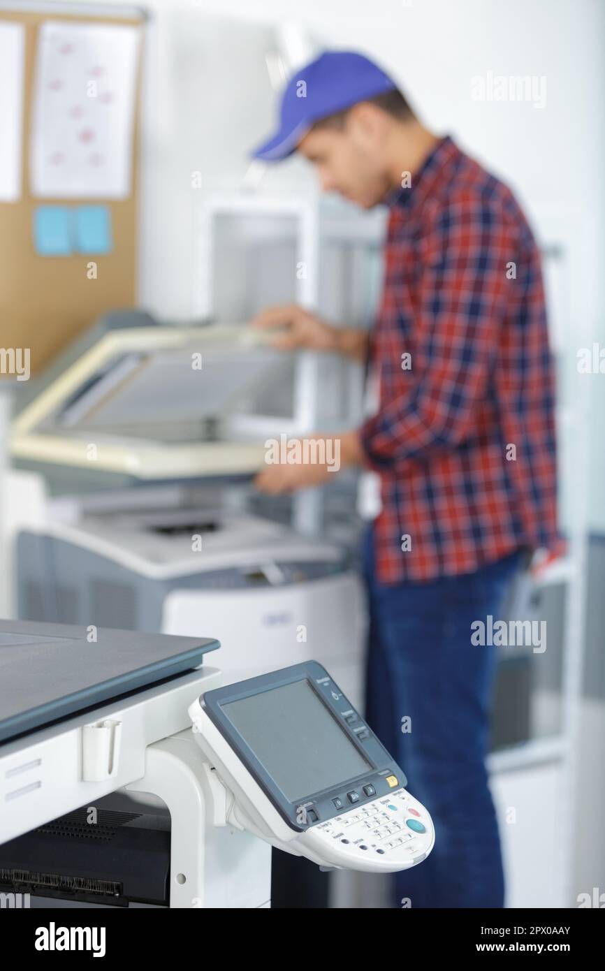 man in office repairing a photocopier Stock Photo - Alamy