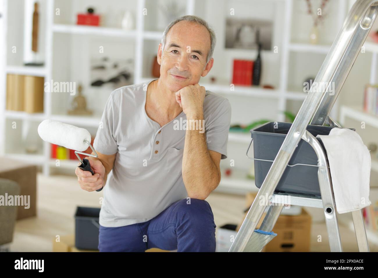 senior painter climbed up a ladder painting with a roller Stock Photo ...