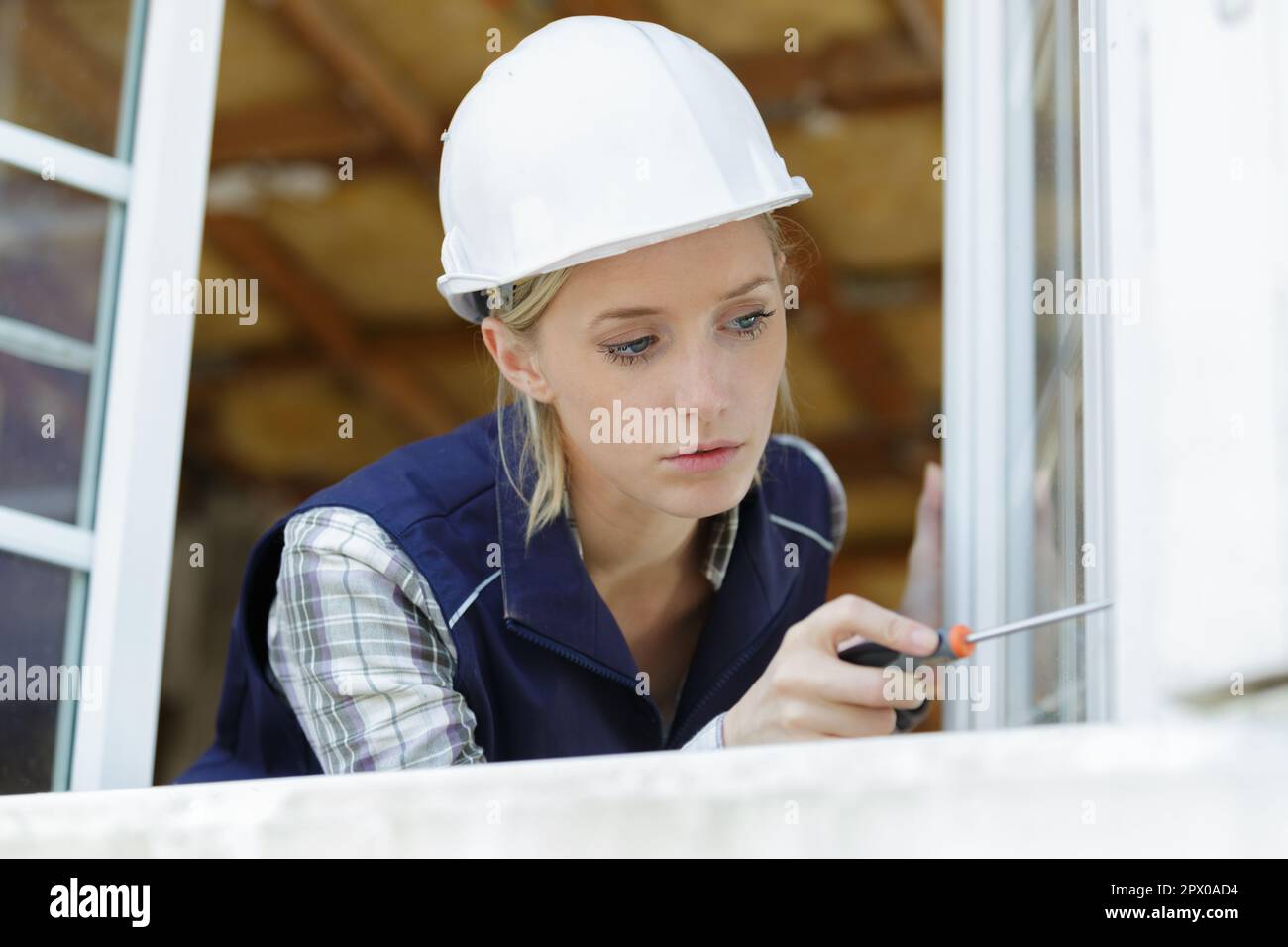 female window fitter using screwdriver Stock Photo - Alamy