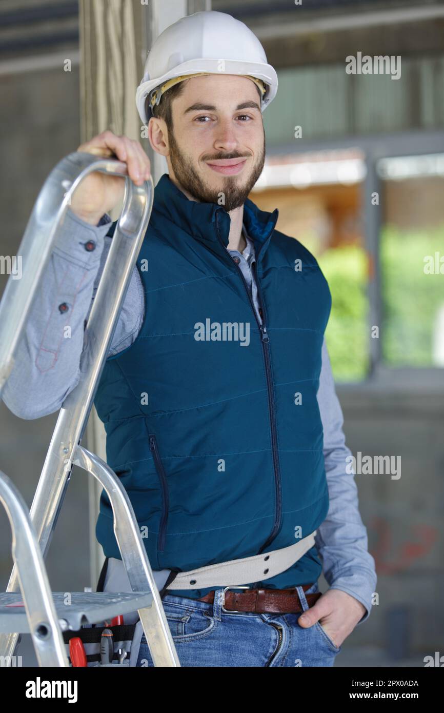 young male construction worker by stepladder Stock Photo - Alamy