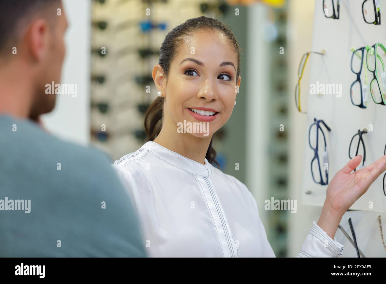 female optician recommending eyeglasses to frame to client Stock Photo ...