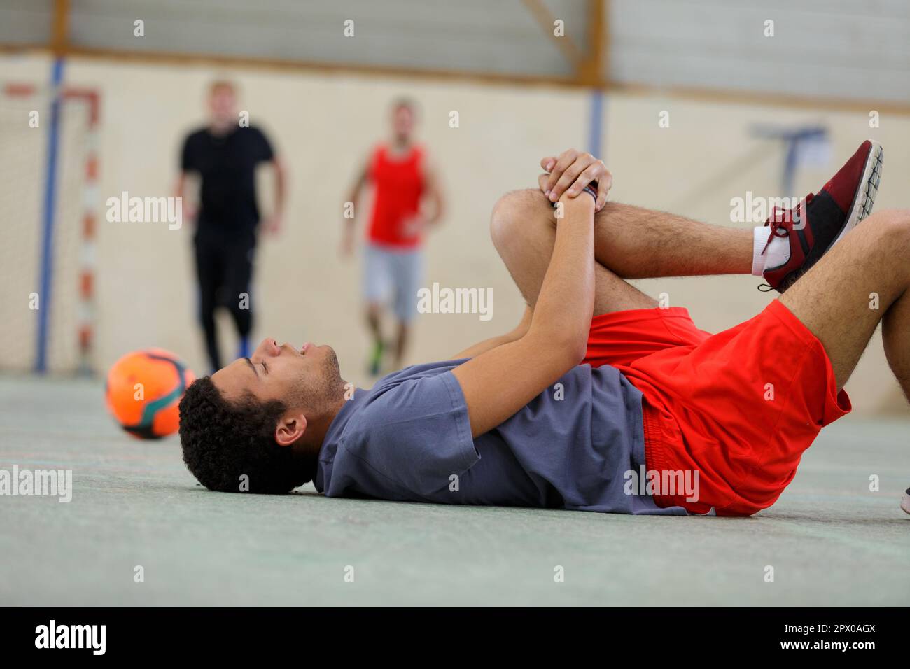 physiotherapist running to help football player Stock Photo - Alamy