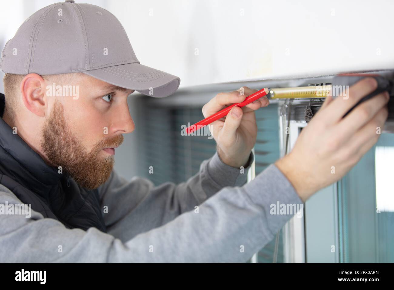 service man installing window with measure tape Stock Photo - Alamy