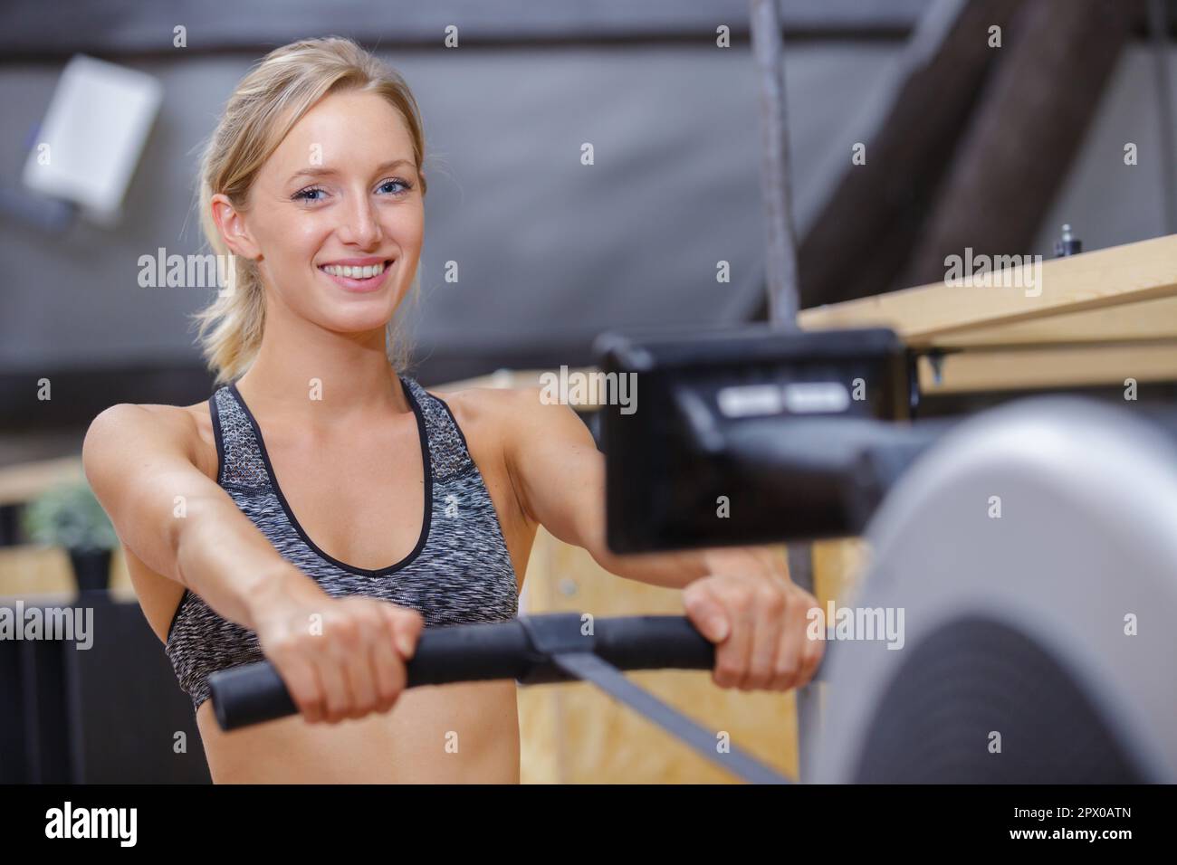 sporty girl working out on a rowing machine at gym Stock Photo - Alamy