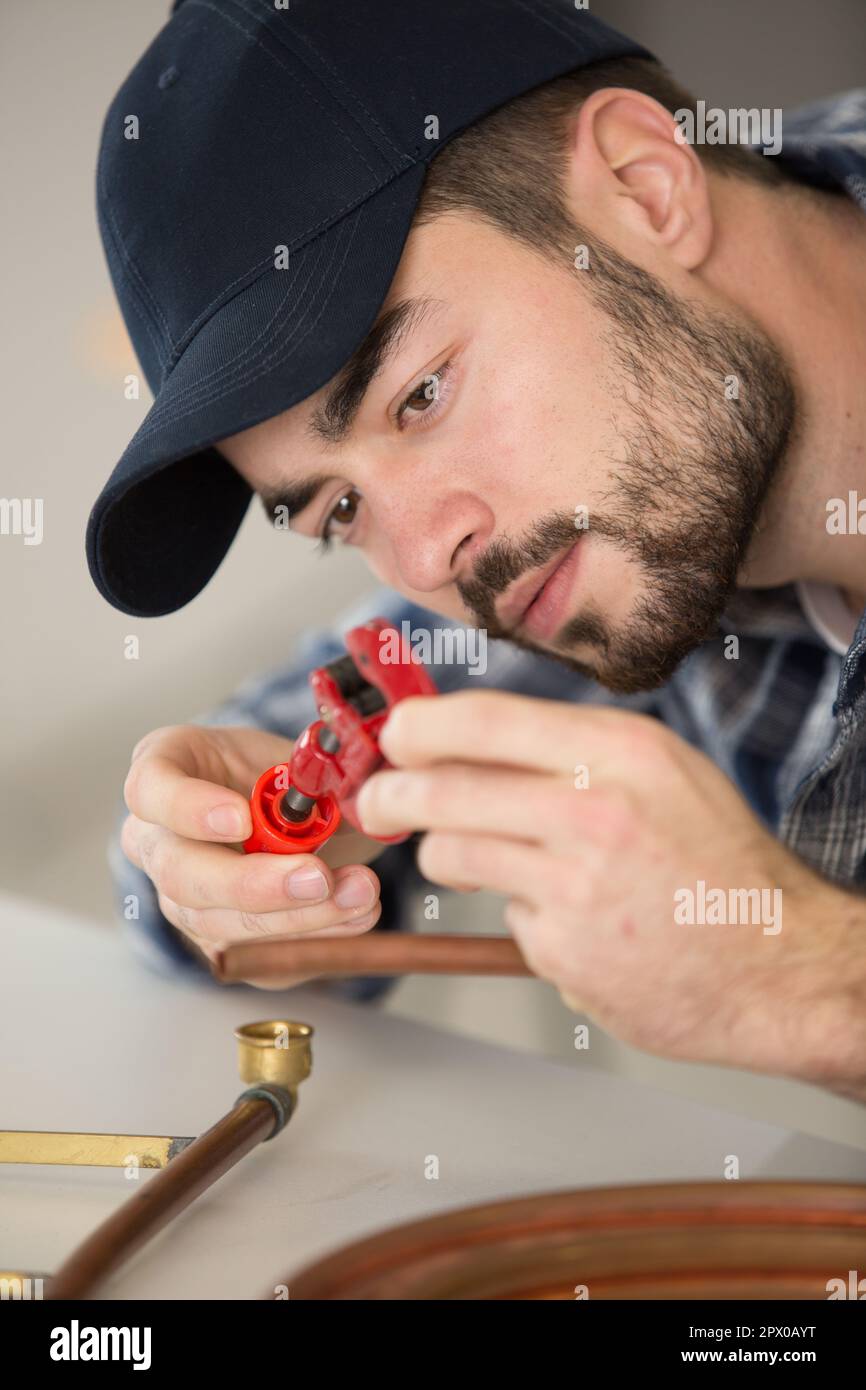young worker using copper pipes and fittings Stock Photo - Alamy