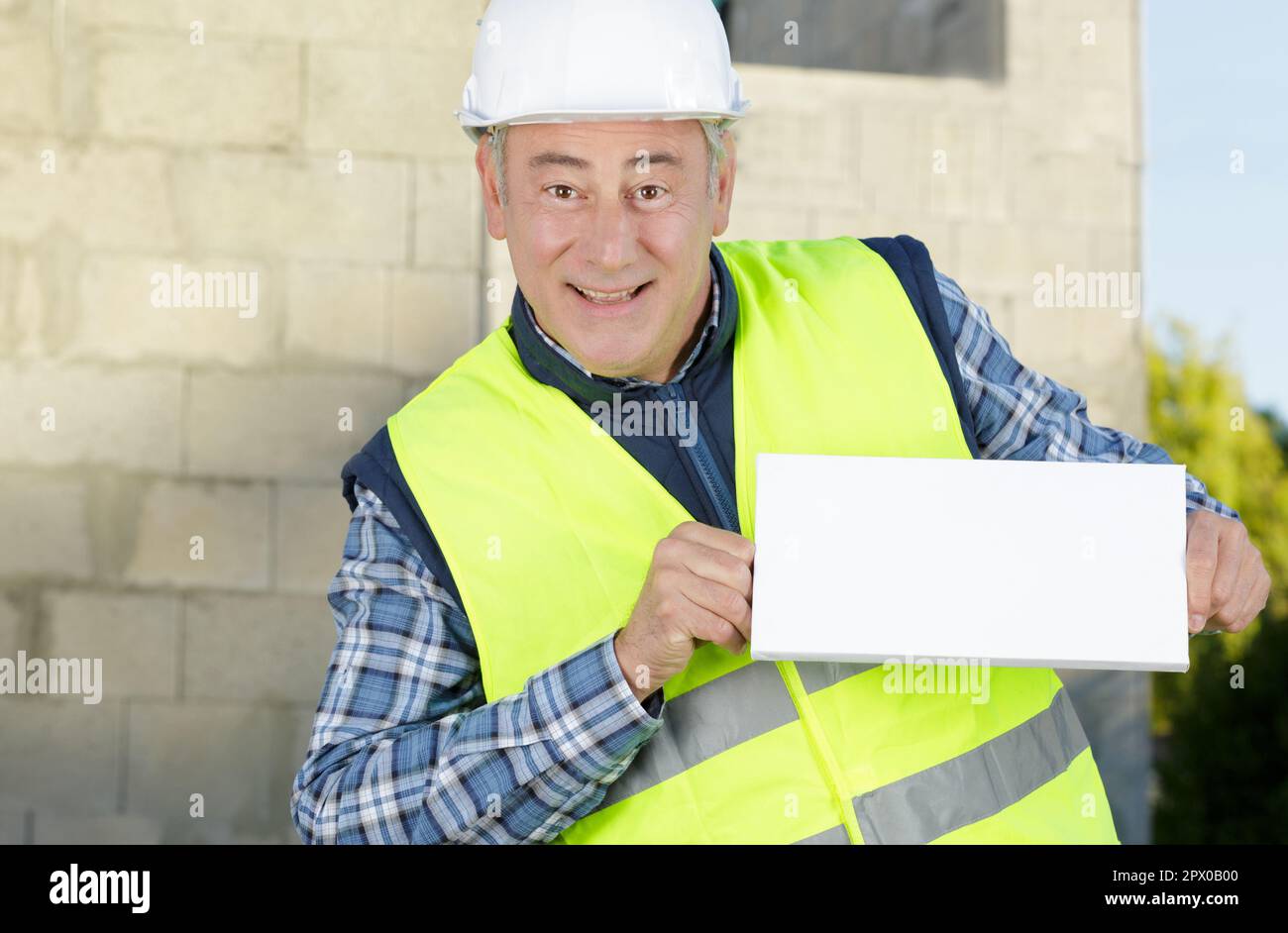 a male builder shows banner Stock Photo - Alamy