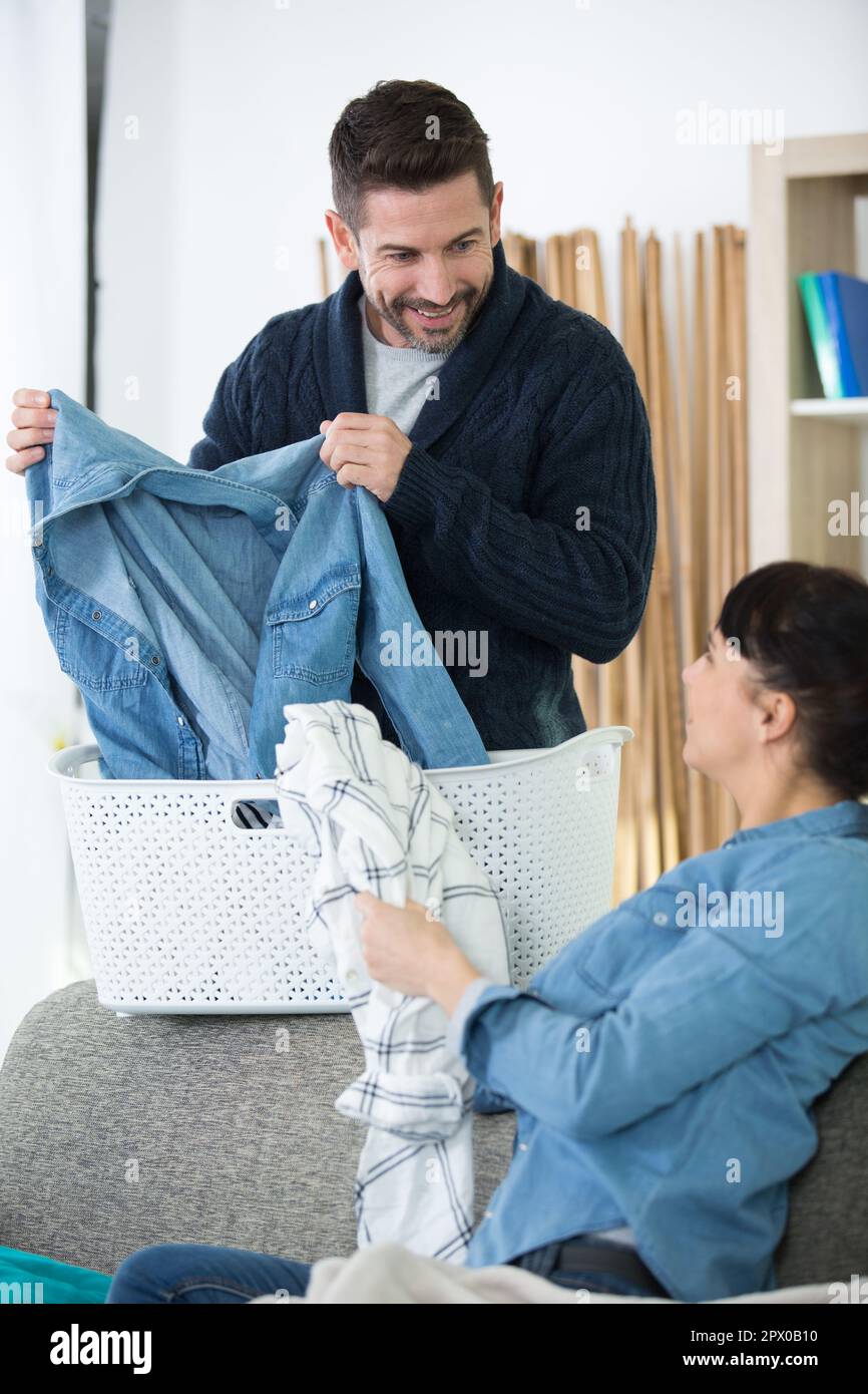 cheerful couple sorting laundry together Stock Photo - Alamy