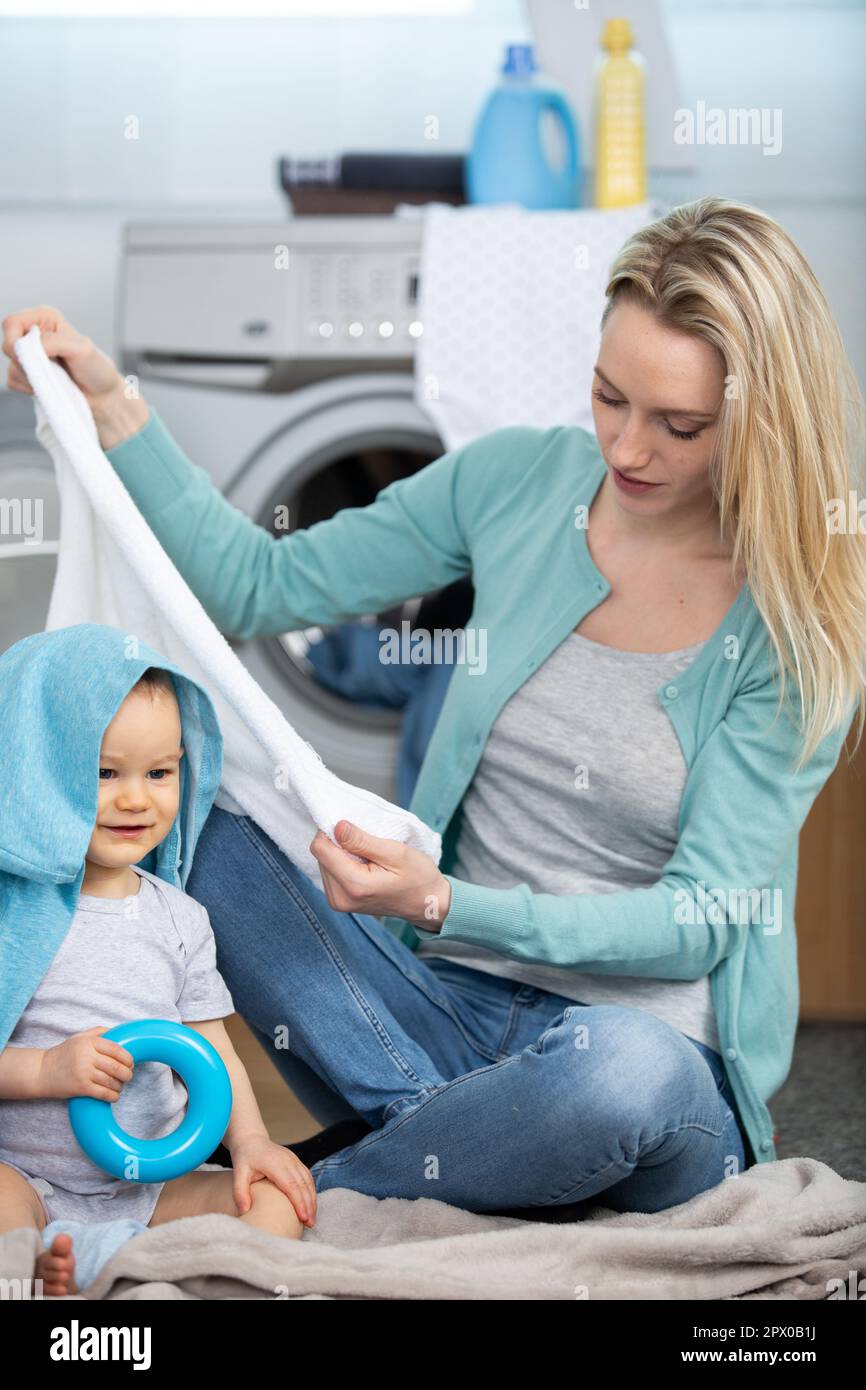 mother and baby next to washing machine Stock Photo - Alamy