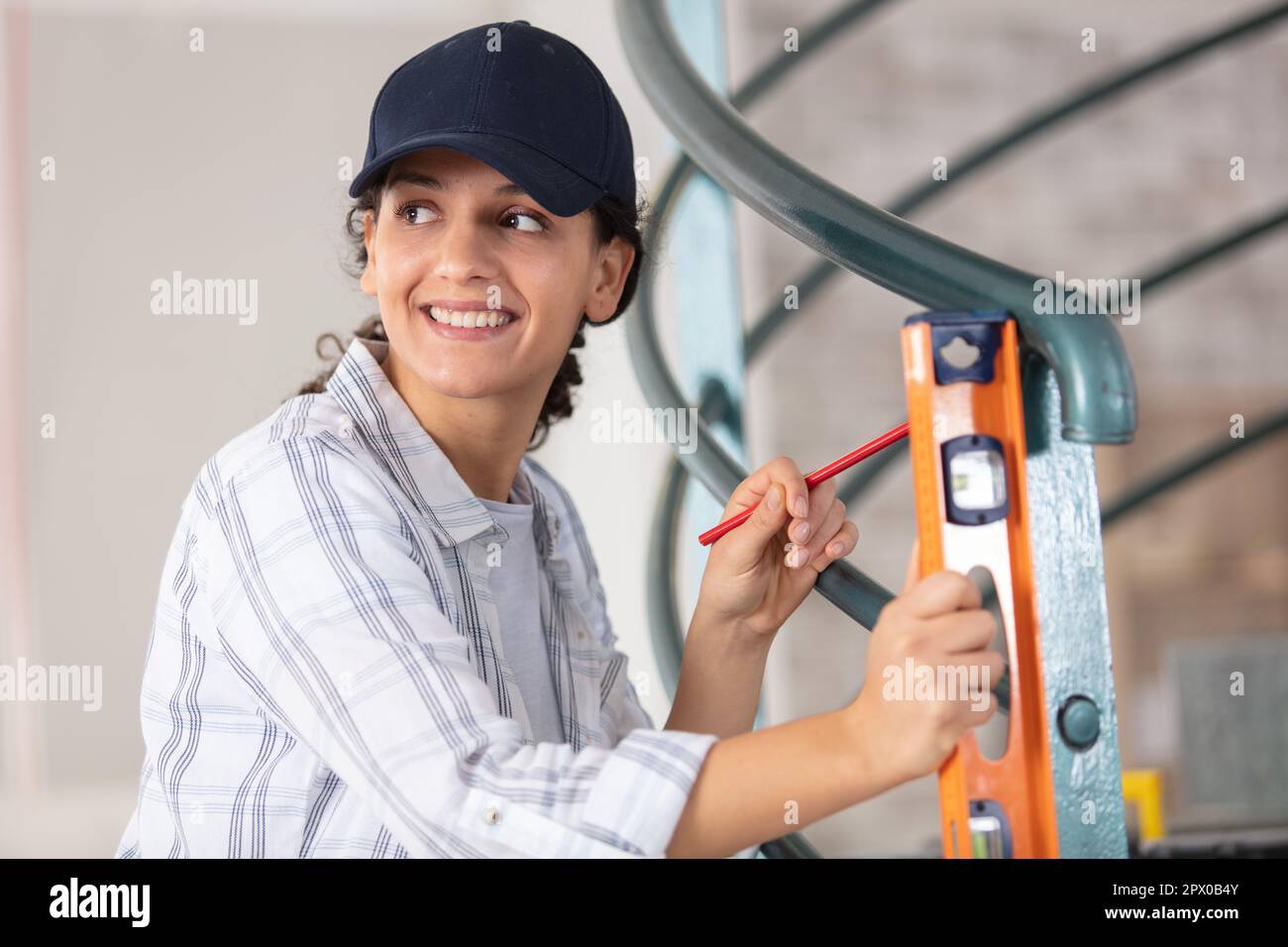 young woman working on stairs with spirit level Stock Photo - Alamy