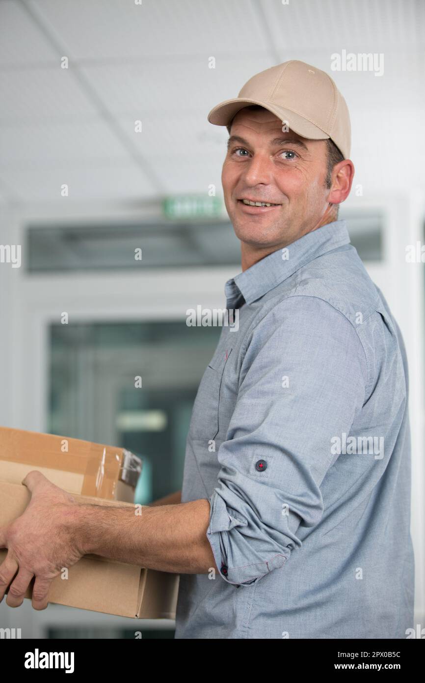 mover with cardboard box at indoors of apartment Stock Photo - Alamy