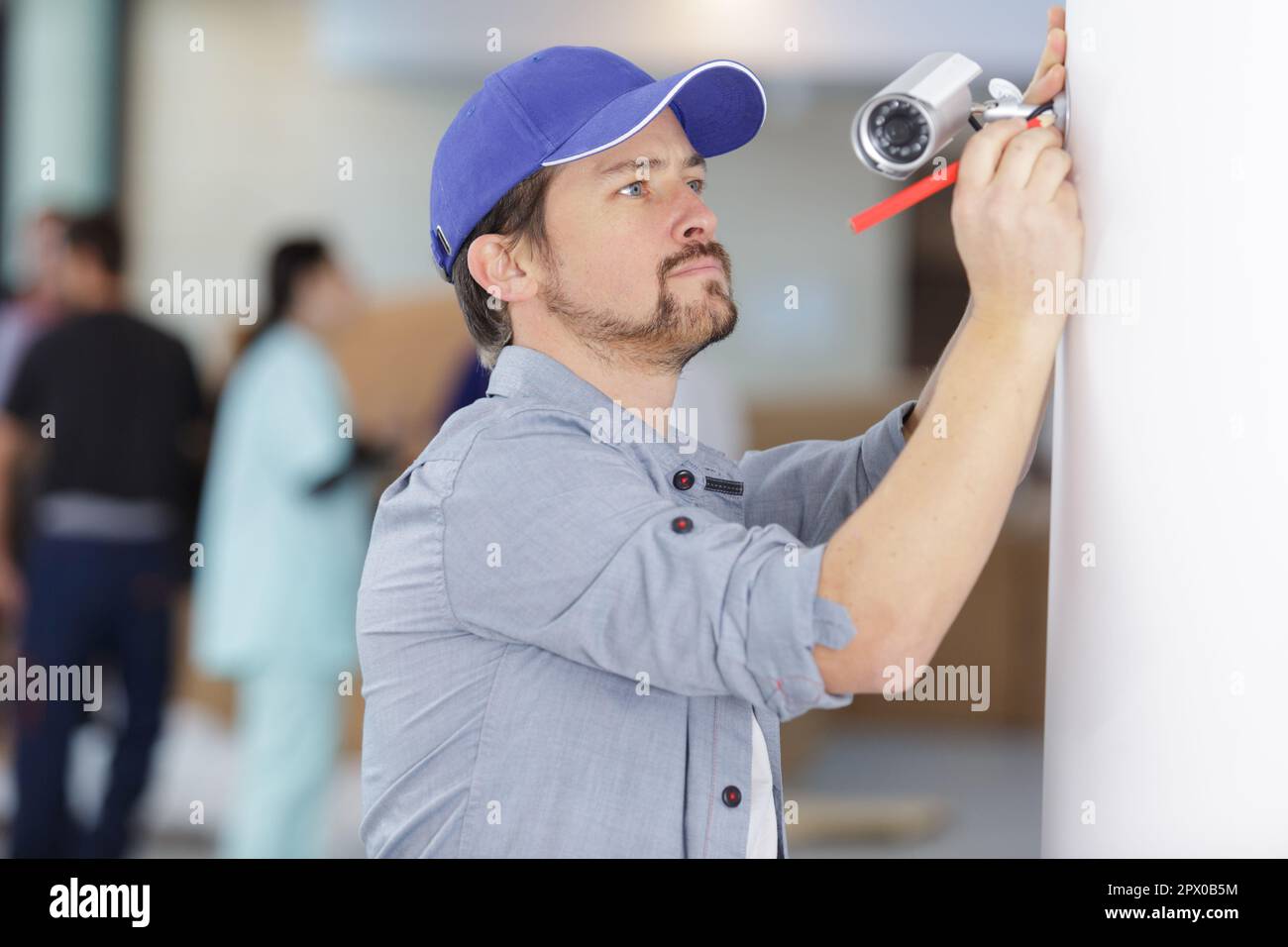 man installing security camera in a hospital Stock Photo - Alamy