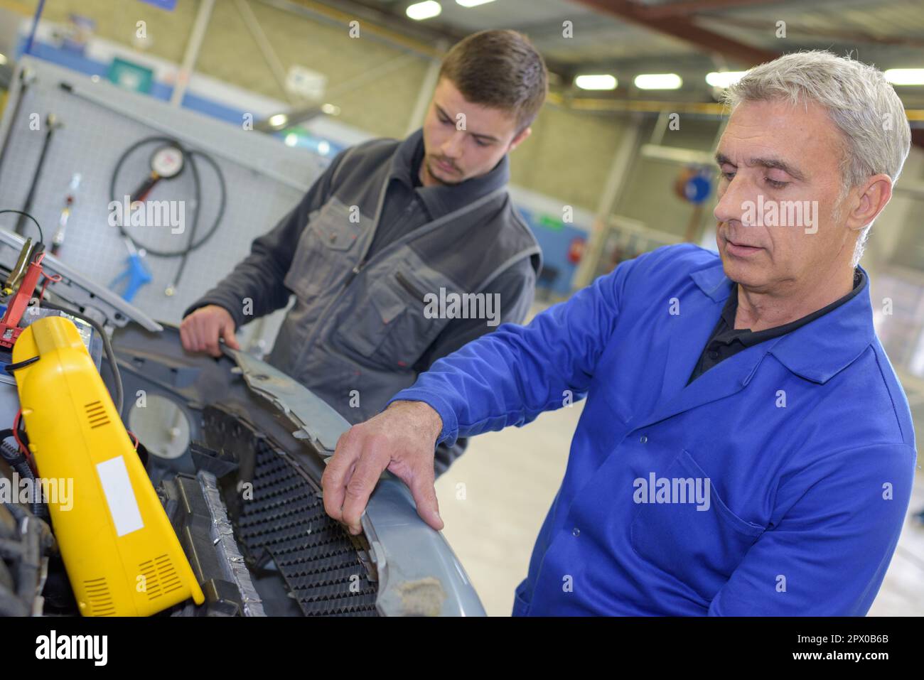 apprentice mechanic in auto shop working on car engine Stock Photo - Alamy