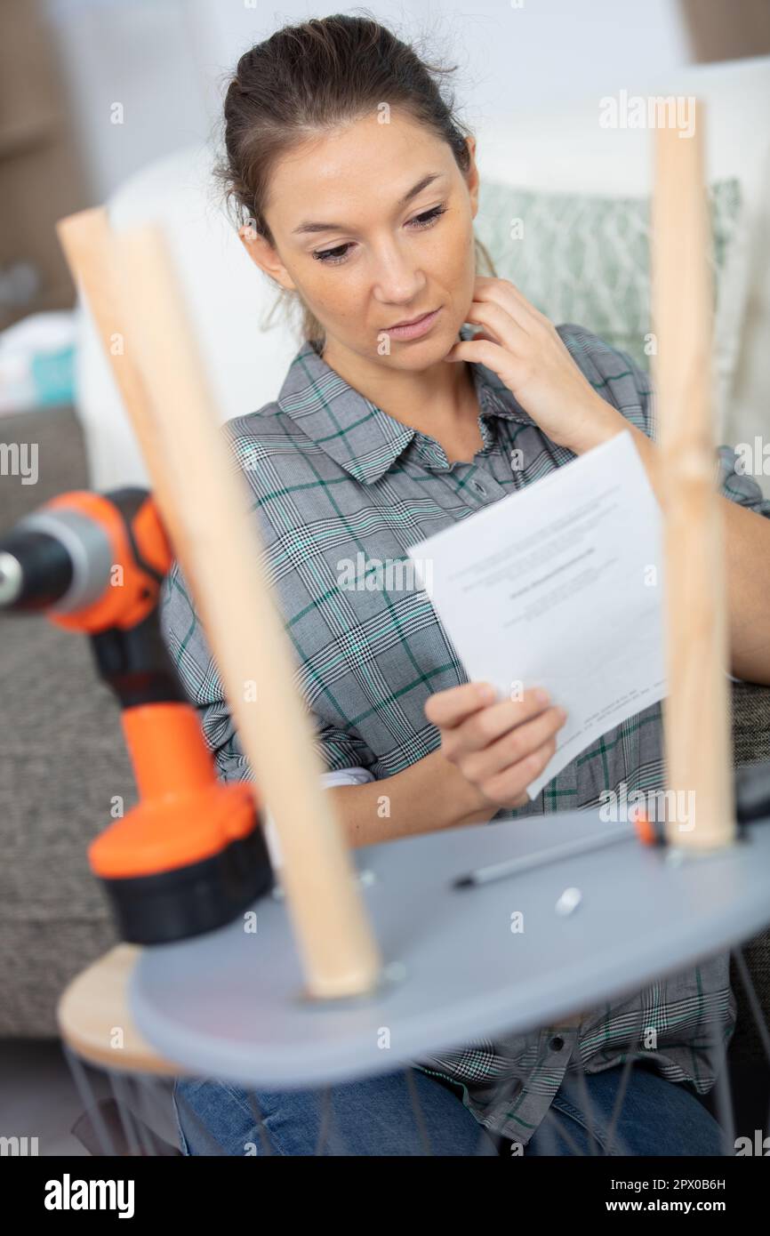 woman reading instructions for assembling furniture Stock Photo - Alamy