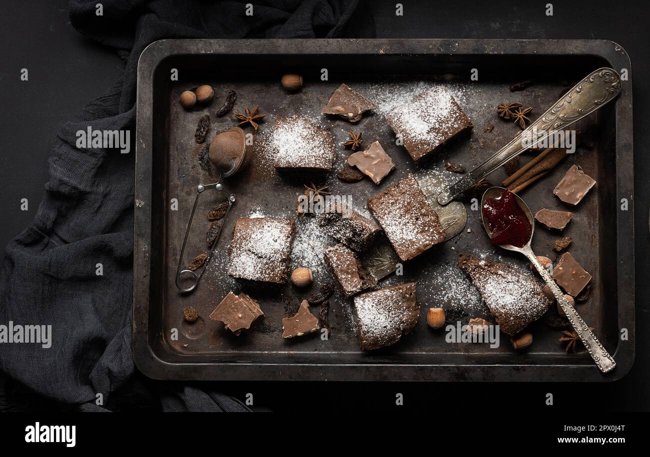 Baked square pieces of chocolate brownie sprinkled with powdered sugar ...