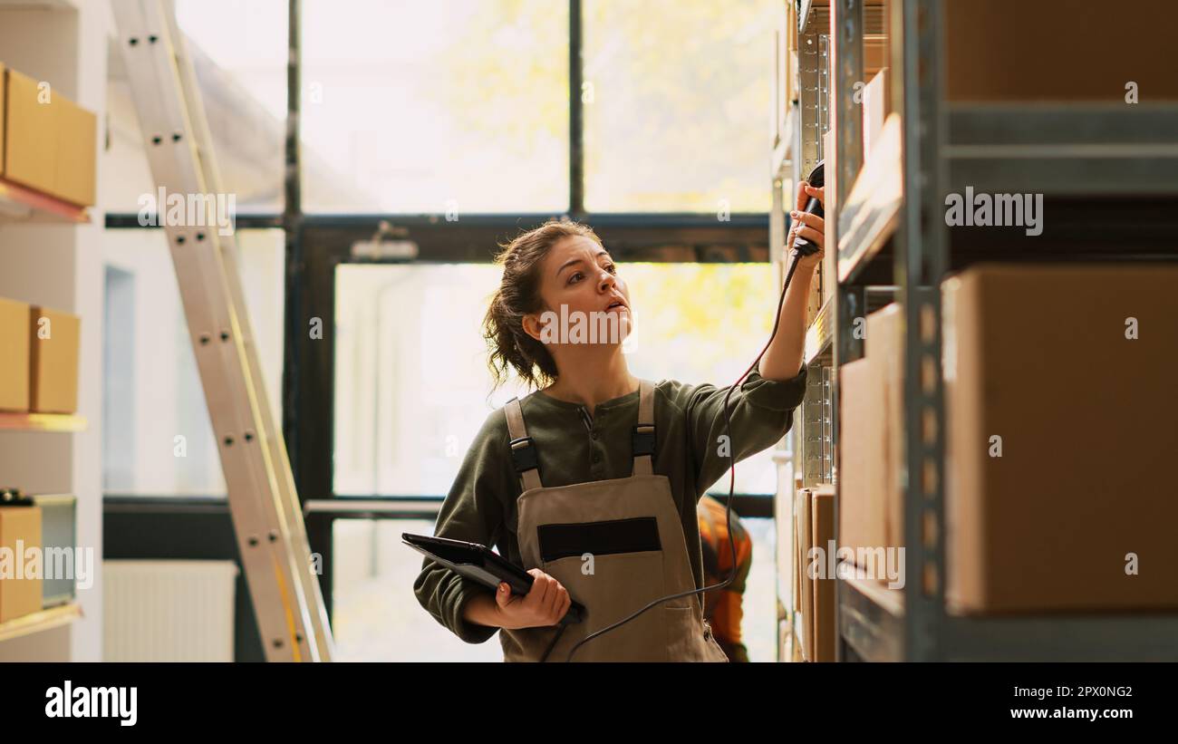 Warehouse employee scanning goods in boxes, working with tablet and ...