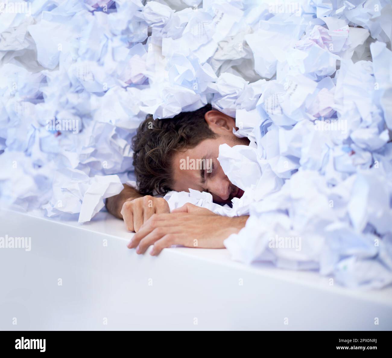 Letting his work consume him. a businessman buried under a pile of ...