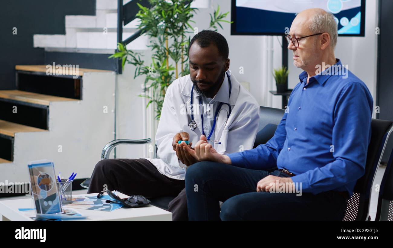 Doctor doing insulin level measurement with medical glucometer and ...