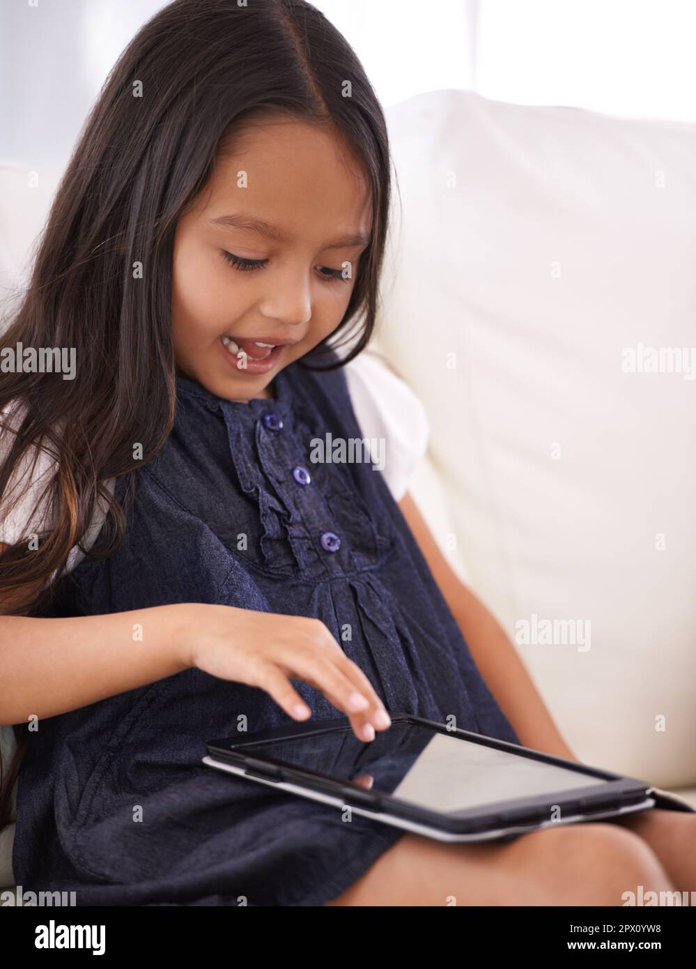 Growing up in the digital age. a little girl using a tablet while ...