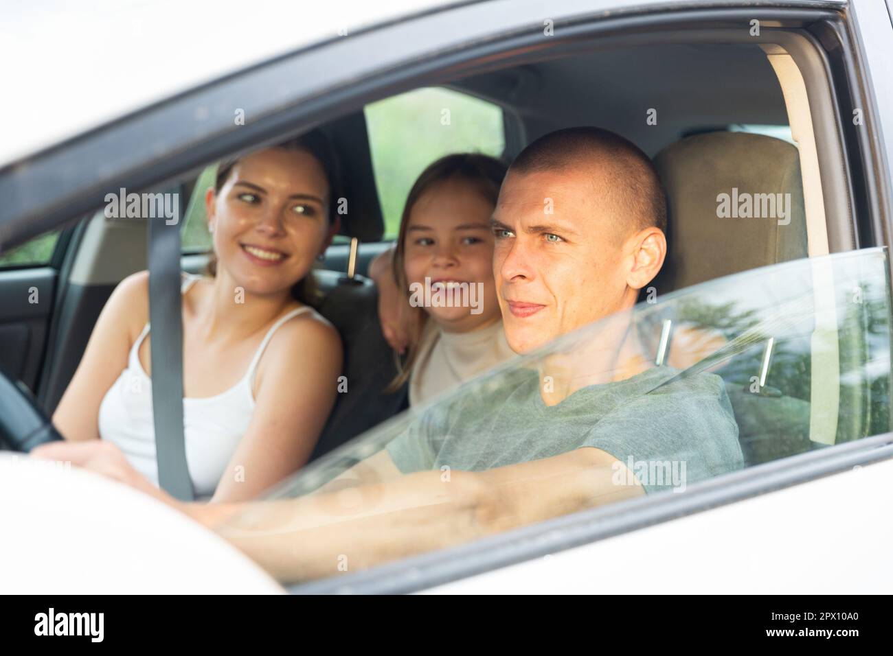 Positive family of three driving in the car Stock Photo - Alamy