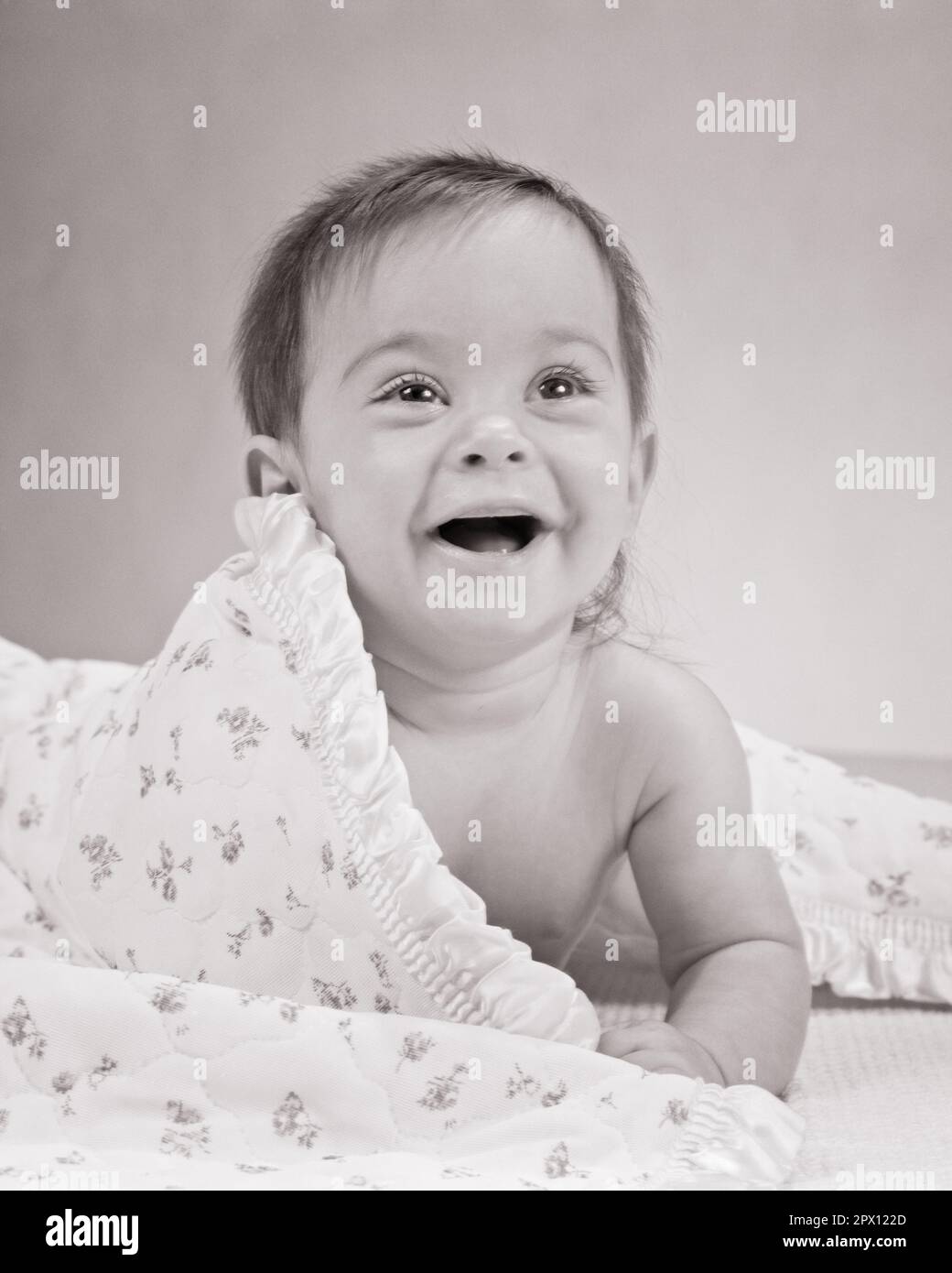 1970s SMILING BRUNETTE BABY GIRL CRAWLING OUT FROM UNDER A BLANKET ...