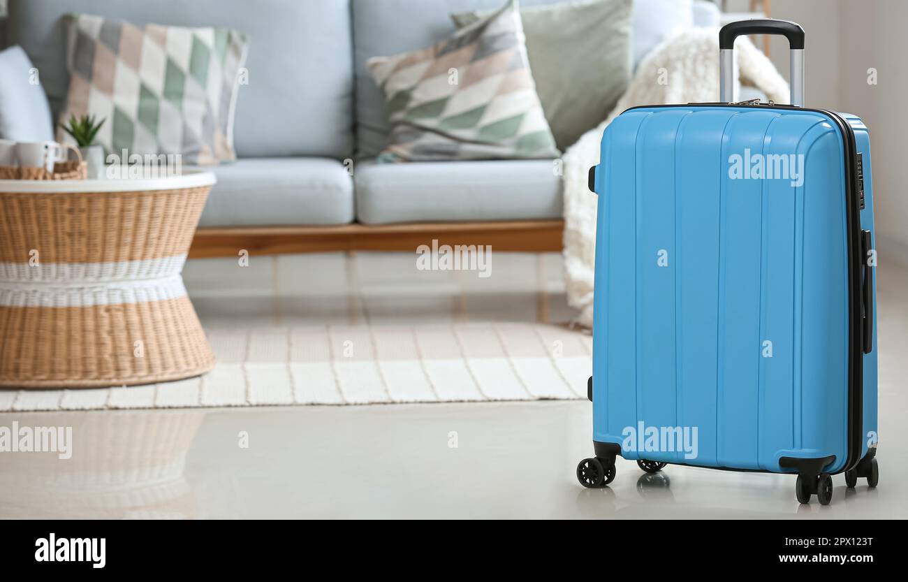 Blue packed suitcase in room. Travel concept Stock Photo - Alamy