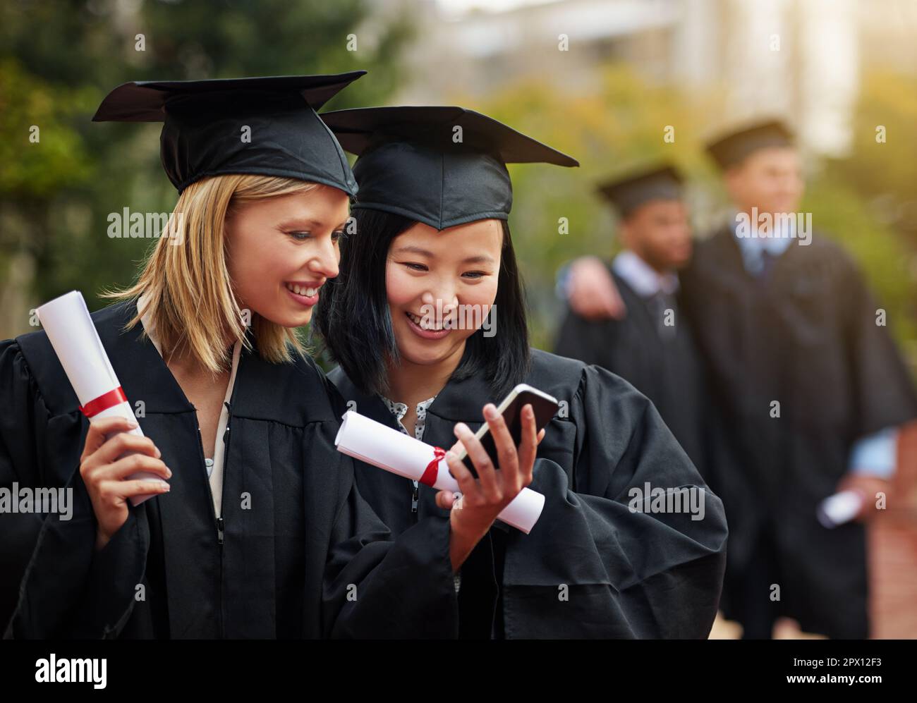 This is such a cute picture of us. two graduates using a cellphone ...