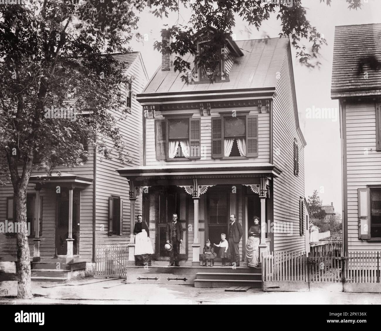 1890s 1900s EXTENDED FAMILY ON FRONT PORCH OF THREE STORY WOOD FRAME ...