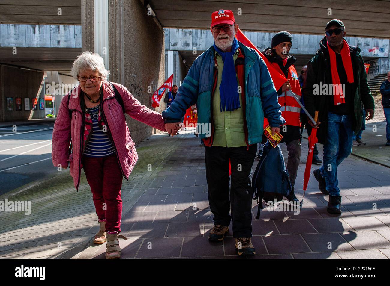 An old couple is seen walking during the march while holding hands. On ...