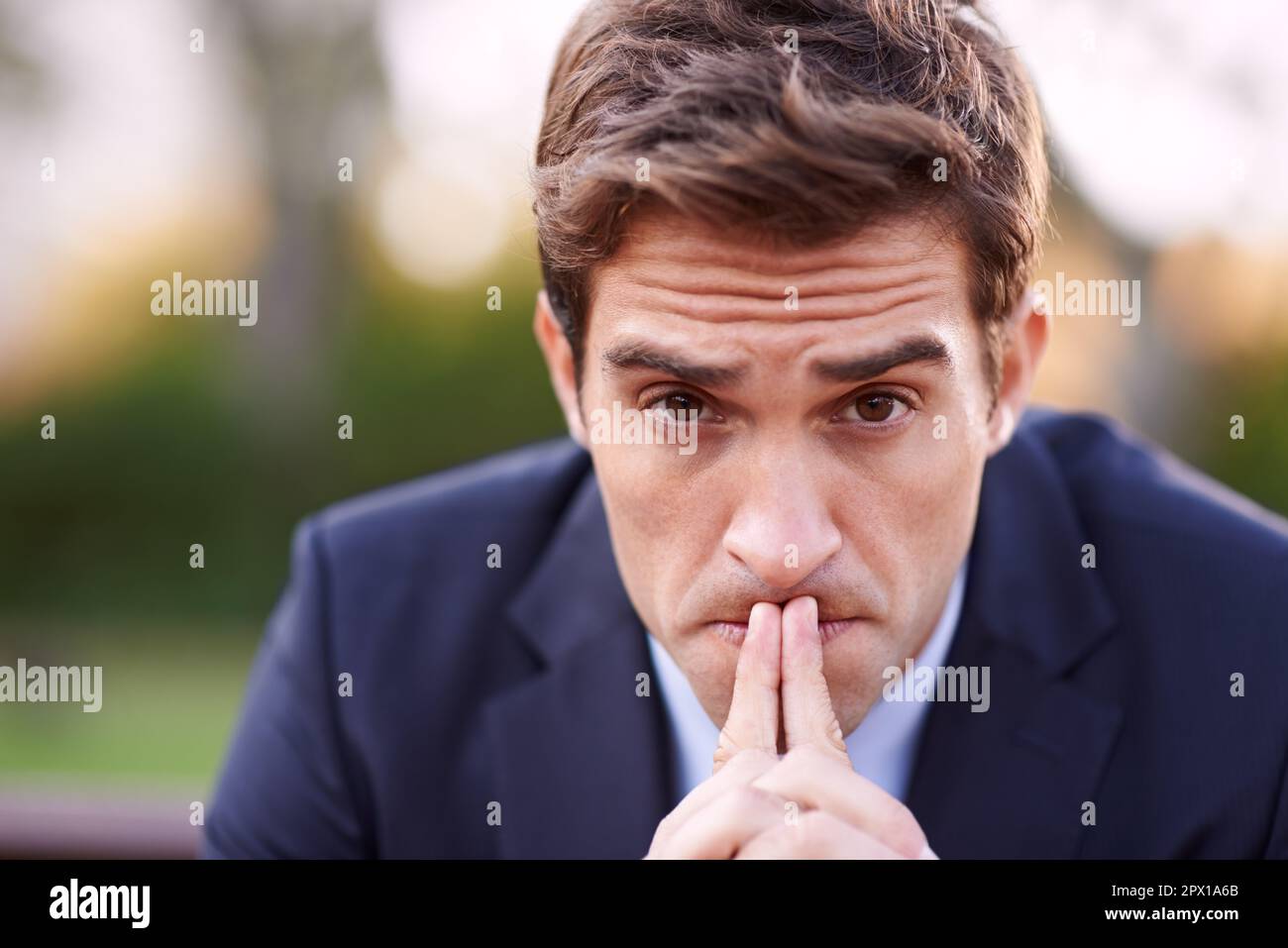 Hes got a lot on his mind. a serious businessman frowning while sitting ...