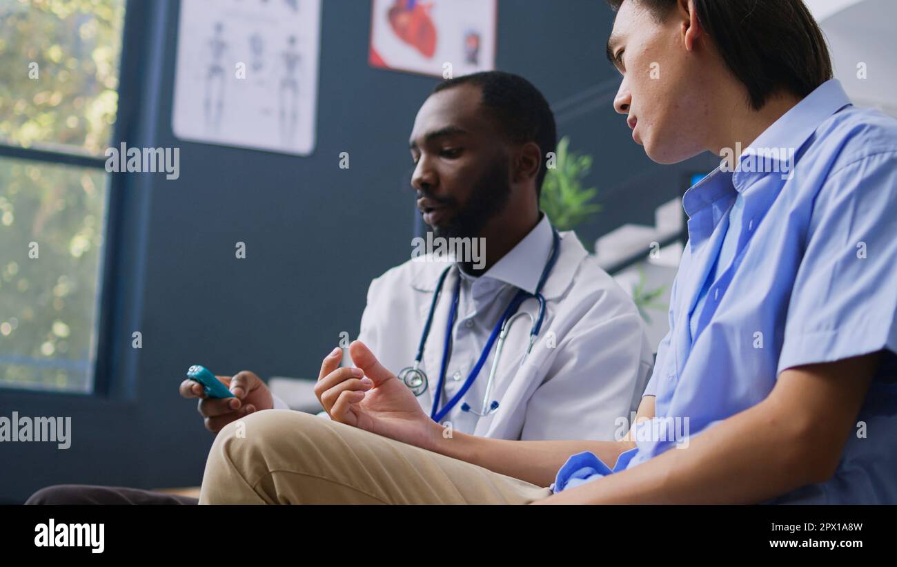 Practitioner measuring sugar level with blood sample to do insulin test ...