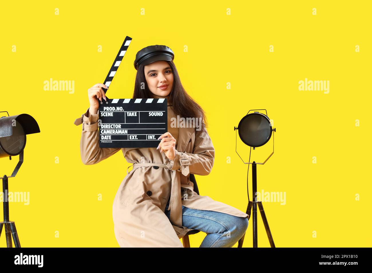 Female film director with movie clapper on yellow background Stock ...