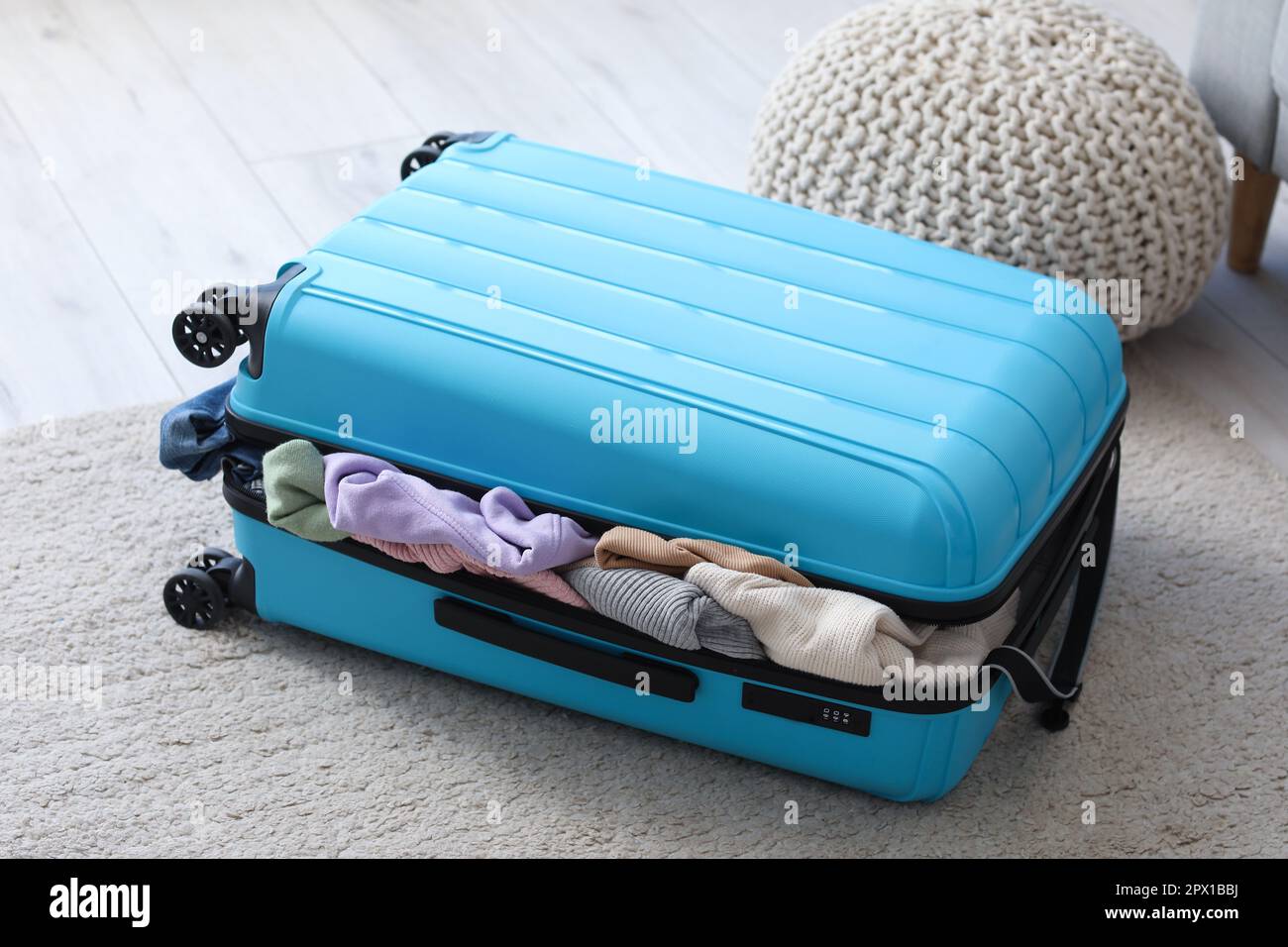 Suitcase full of clothes in living room Stock Photo - Alamy