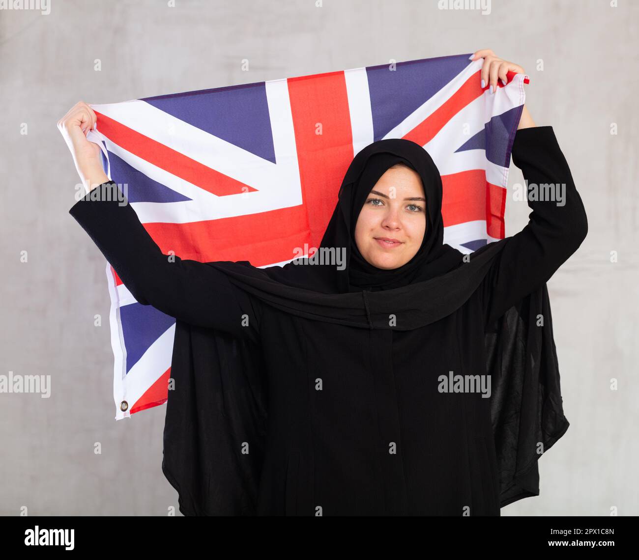 Happy young woman dressed in traditional islamic clothes with british ...