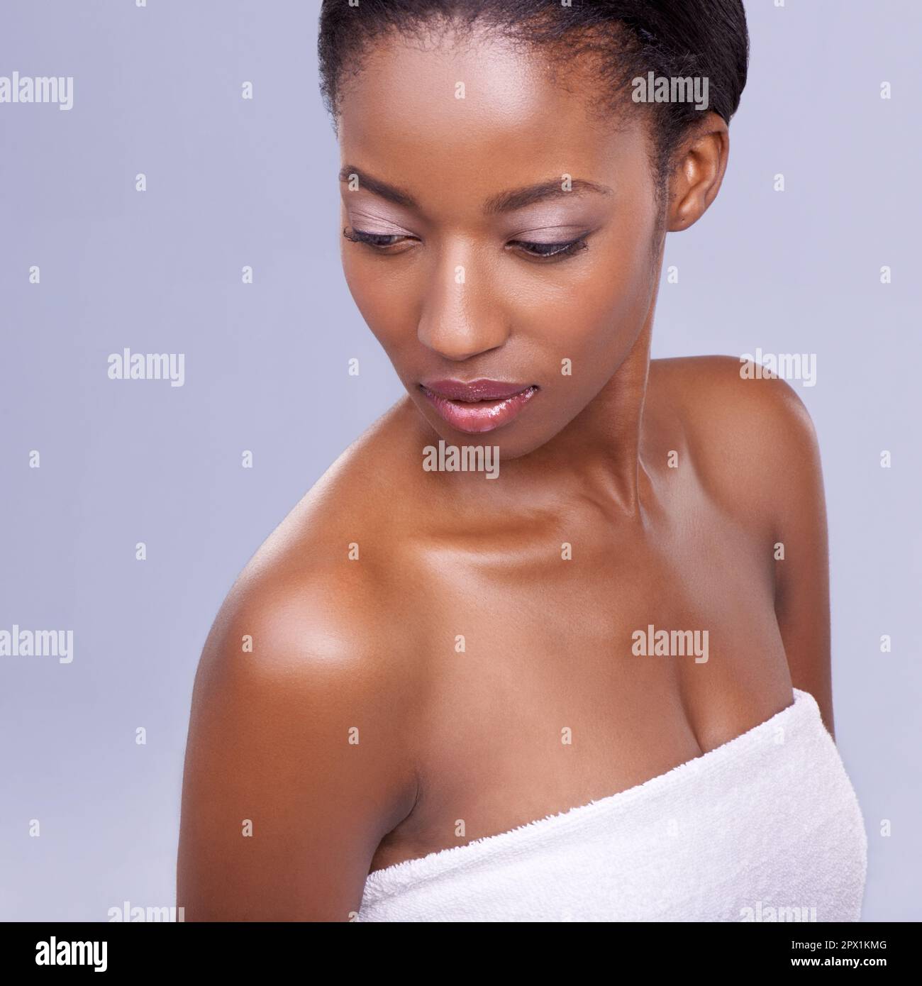Enhancing her natural beauty. a beautiful young woman against a purple ...