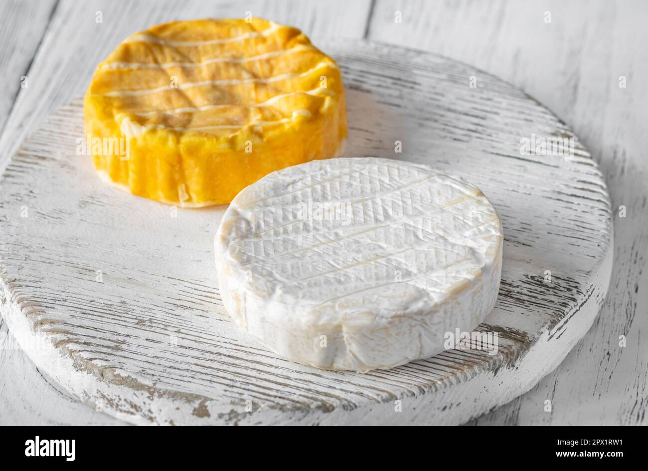 Two camembert cheese wheels on the cutting board Stock Photo - Alamy