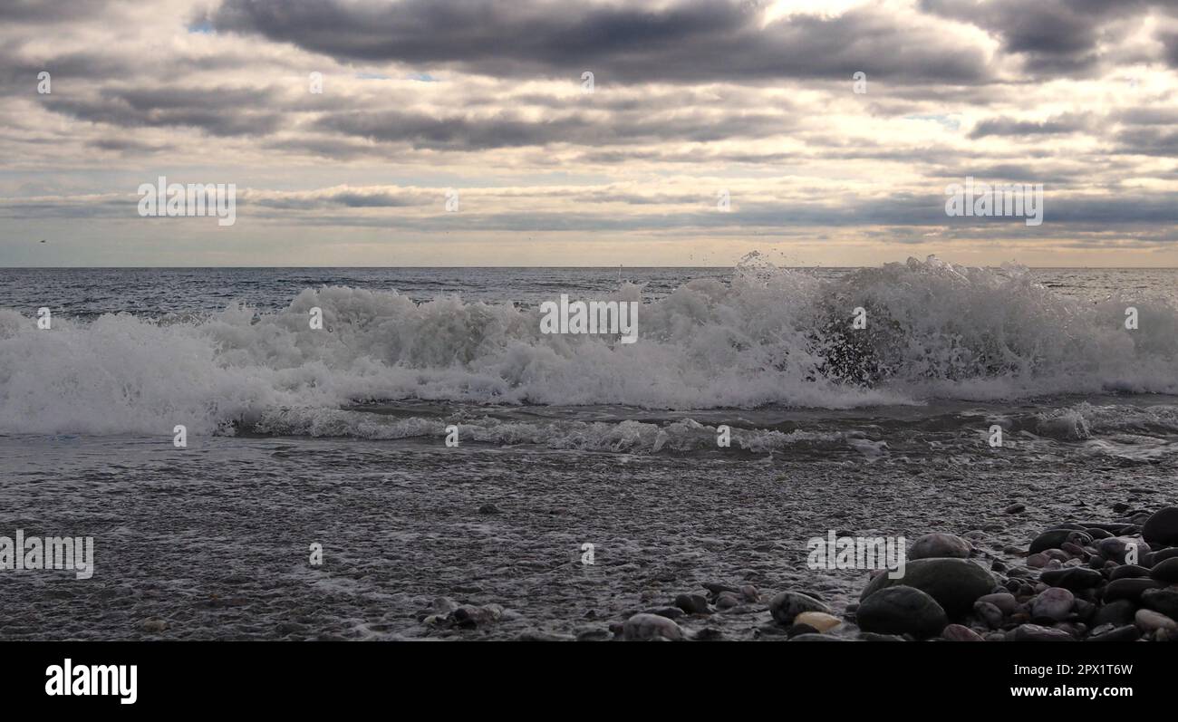 The edge of the sea, views along a pebbled beach as waves reach the ...