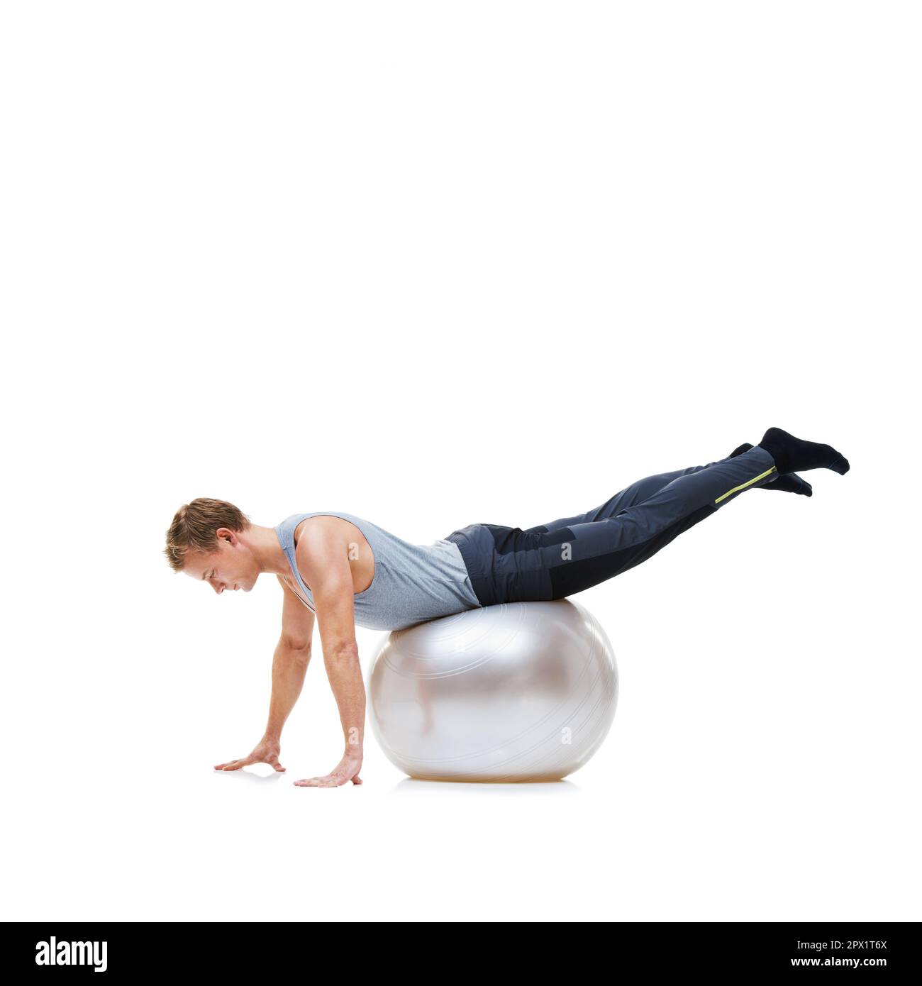 Stretching out his muscles. a man balancing on an exercise ball with a ...