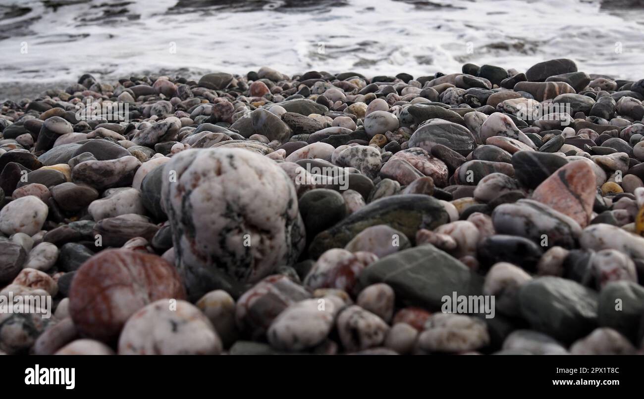 The edge of the sea, views along a pebbled beach as waves reach the ...