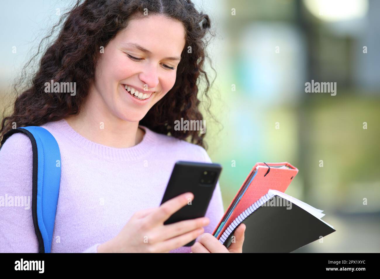 Student walking checking smart phone in a campus Stock Photo - Alamy