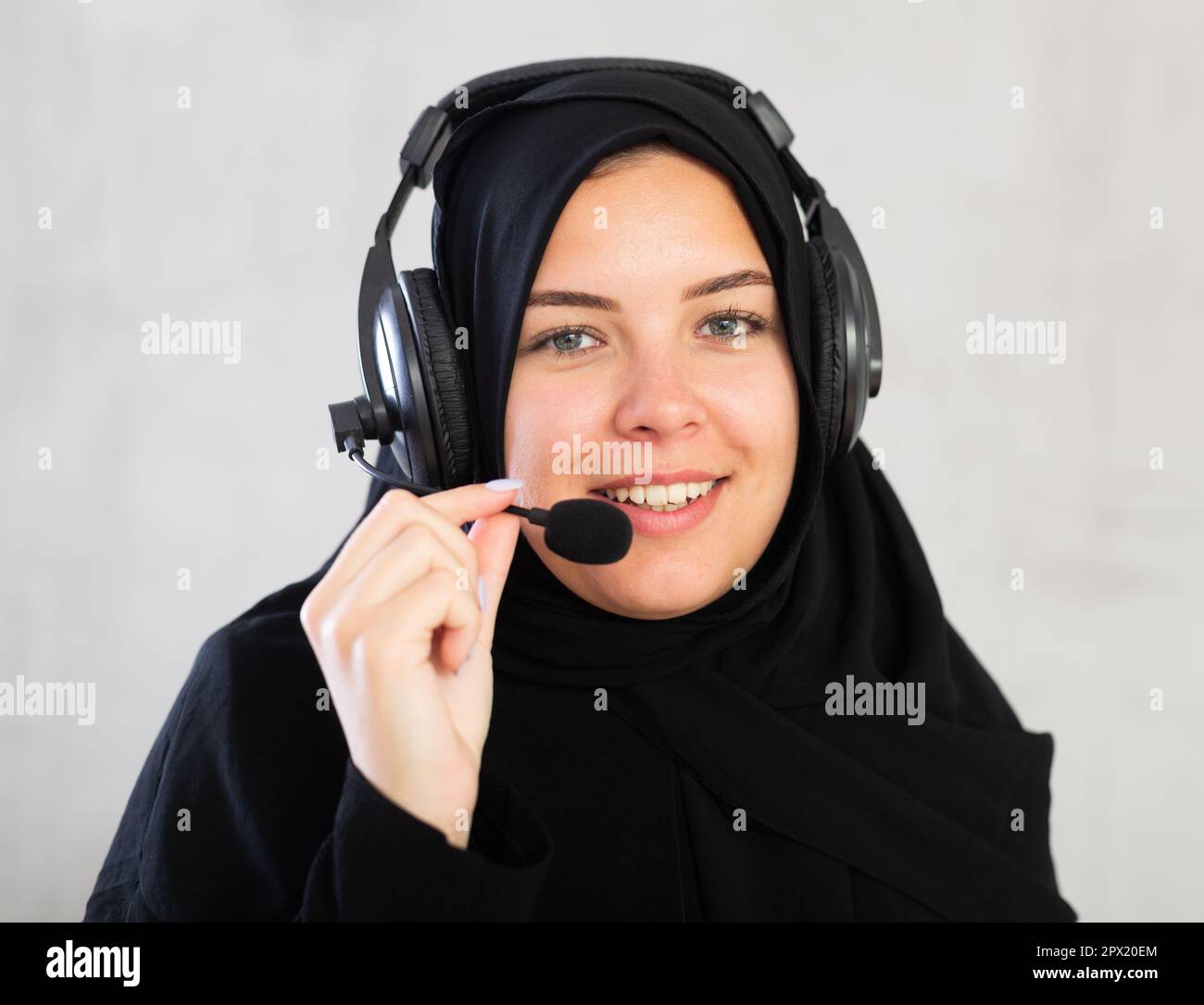 Happy young woman dressed in traditional islamic clothes with ...
