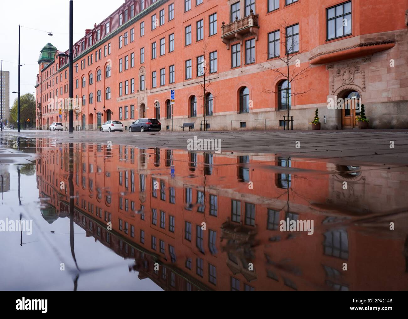 View of puddle on street next to building in city Stock Photo - Alamy
