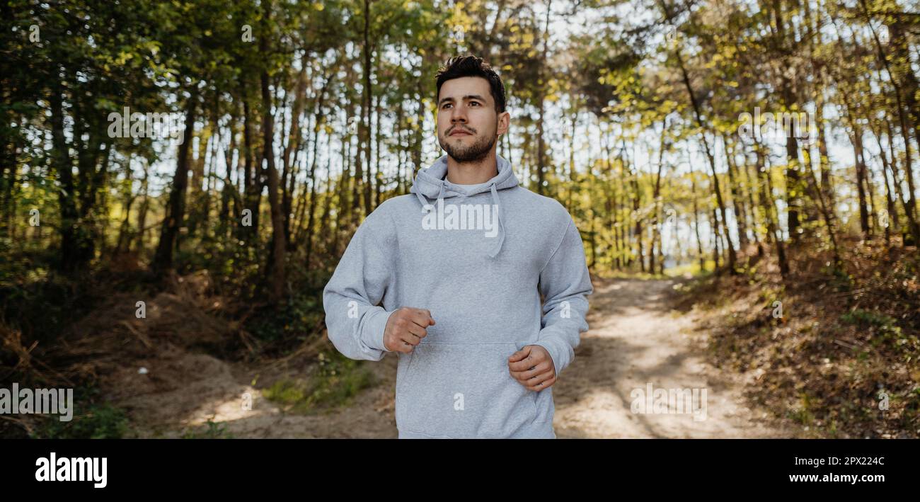 Portrait of jogging male fitness model working out training on forest ...