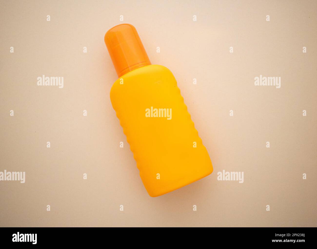 orange plastic Bottle against a sand colored background Stock Photo - Alamy