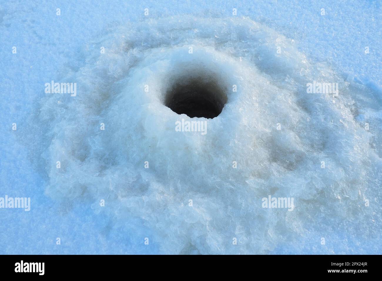 Winter fishing in January. A round hole in the ice and snow, made with ...