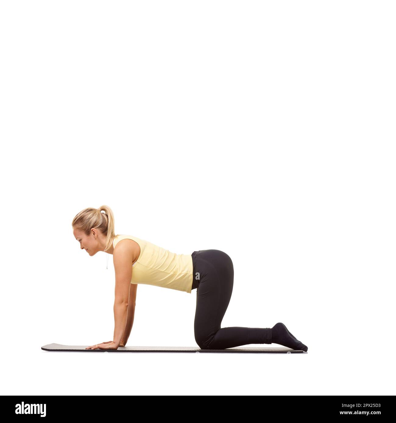 Aligning her back. A fit young woman lowering her back on an exercise ...