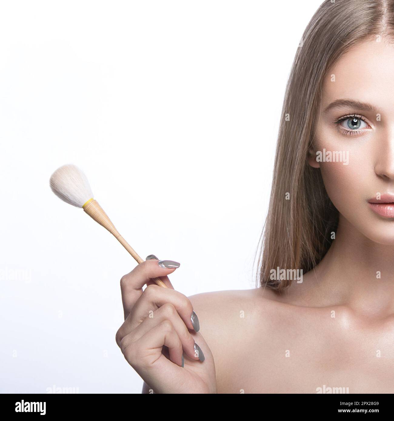 Beautiful young girl with a light natural make-up and beauty tools in ...